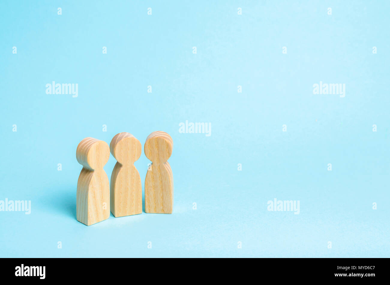 Three people stand together and discuss on a blue background ...