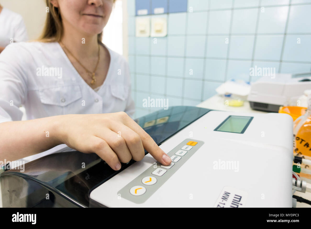 Technician using a PCR (polymerase chain reaction) machine to amplify ...