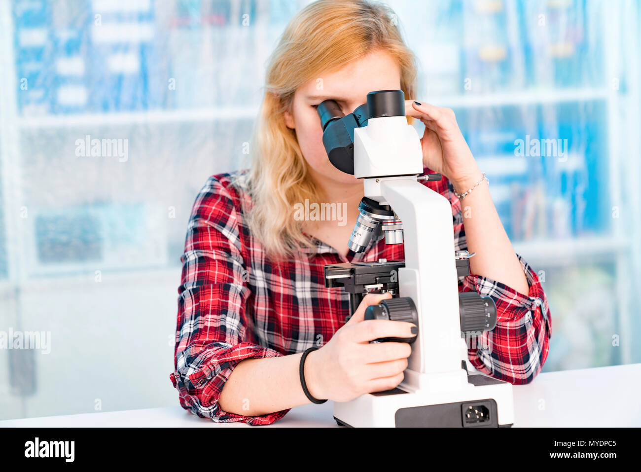 Biology lesson. Student using a light microscope Stock Photo - Alamy