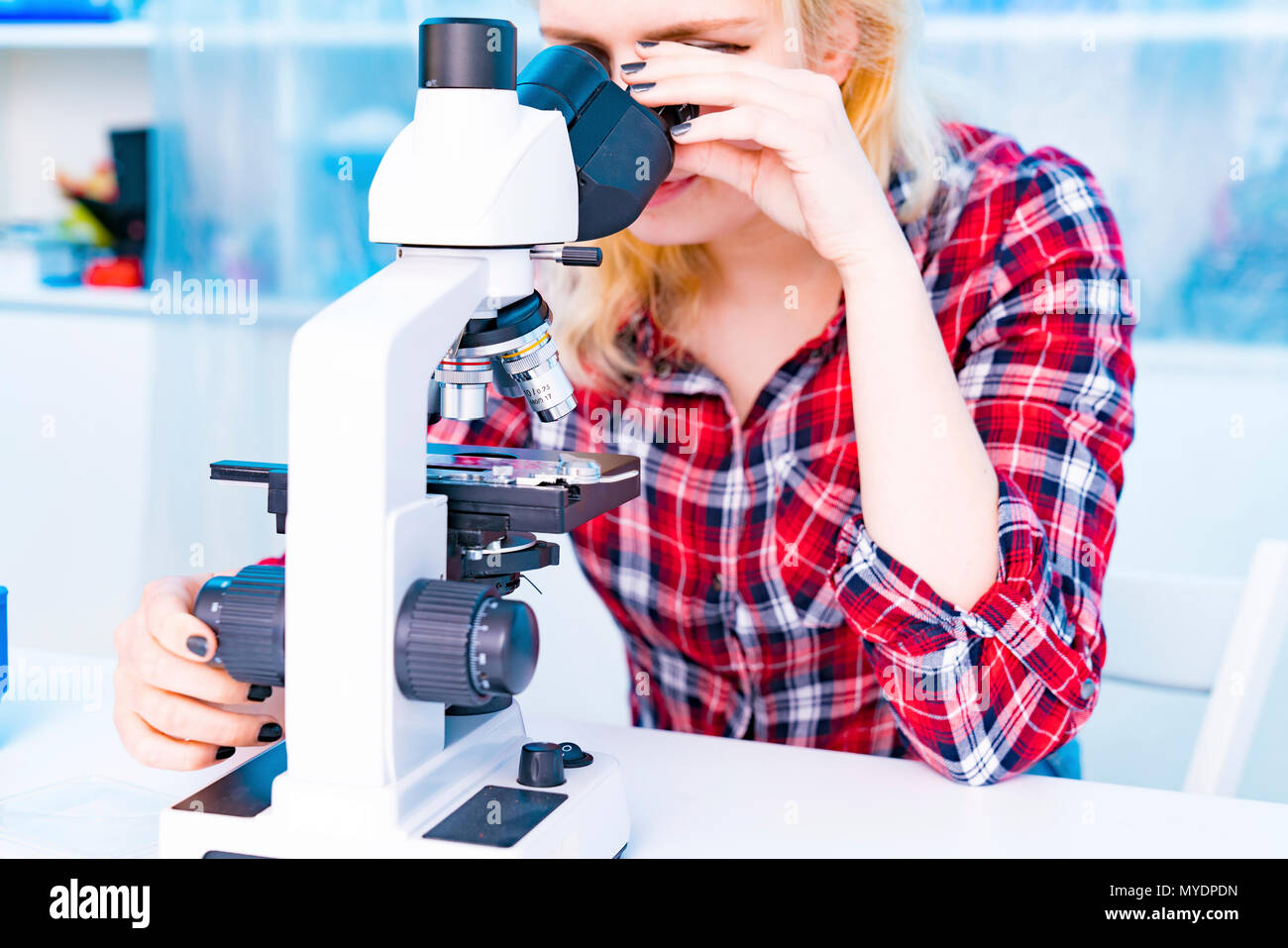 Biology lesson. Student using a light microscope Stock Photo - Alamy