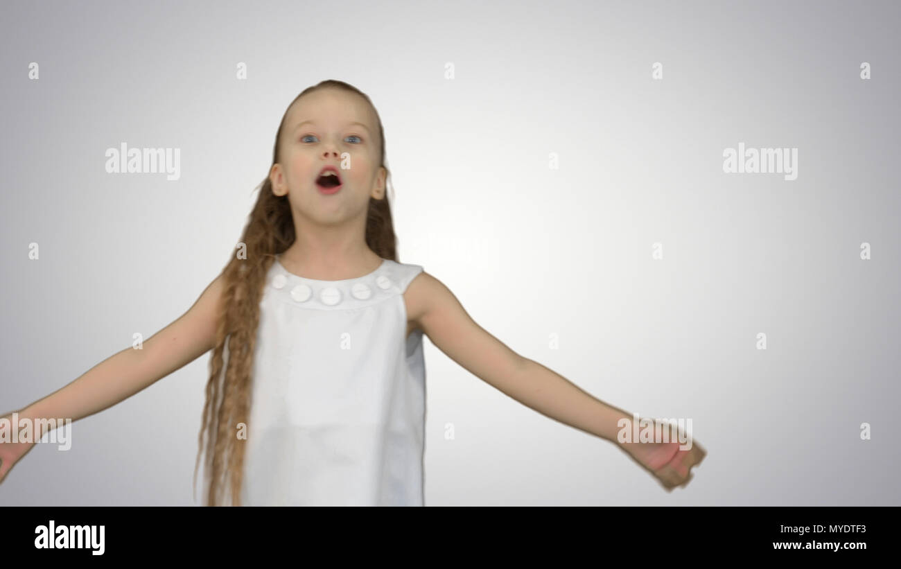 Cute little girl singing a song and dancing on white background Stock ...