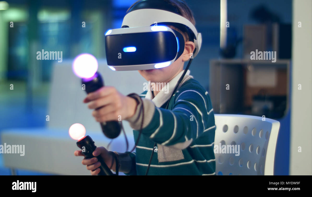 Little boy with virtual reality motion controllers having immersive ...
