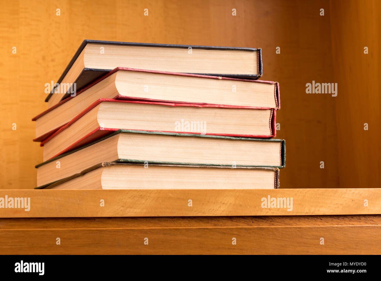 Book stack on wooden desk in classroom Stock Photo - Alamy