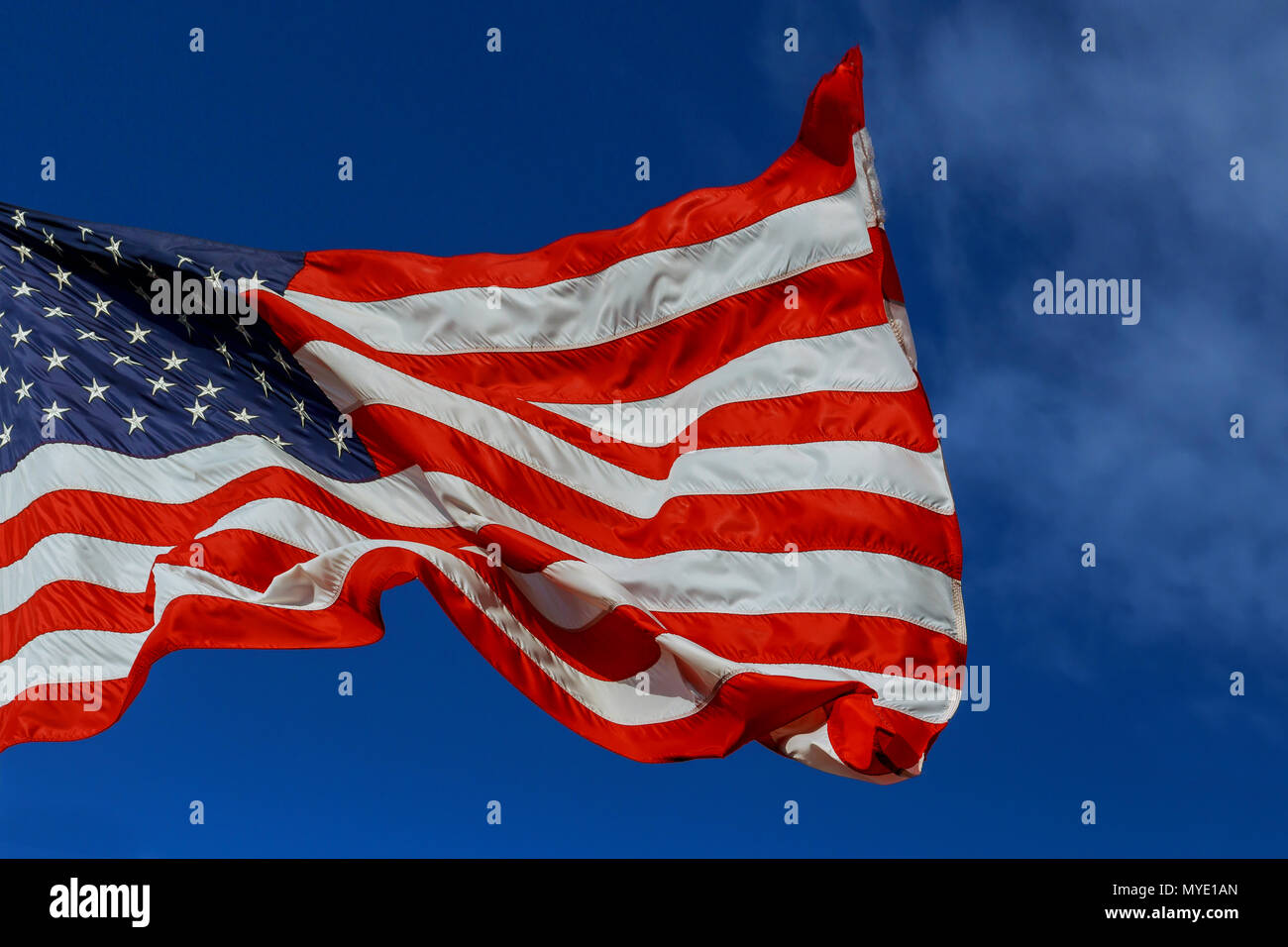 The American Flag waving in blue sky motion blur Stock Photo - Alamy