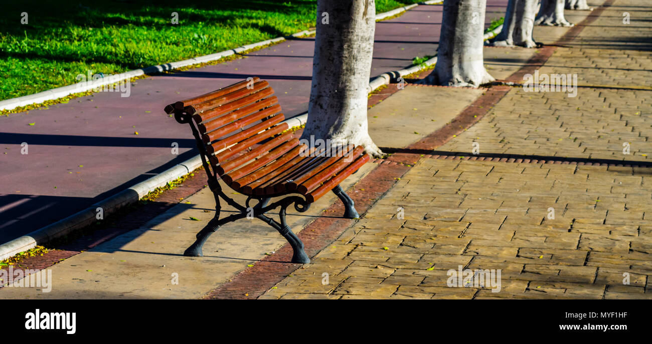wooden bench on the promenade in Spain, a place to rest in the city ...