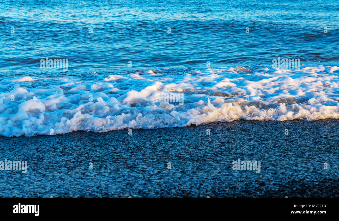 close up of the sea water affecting the sand on the beach, sea waves ...