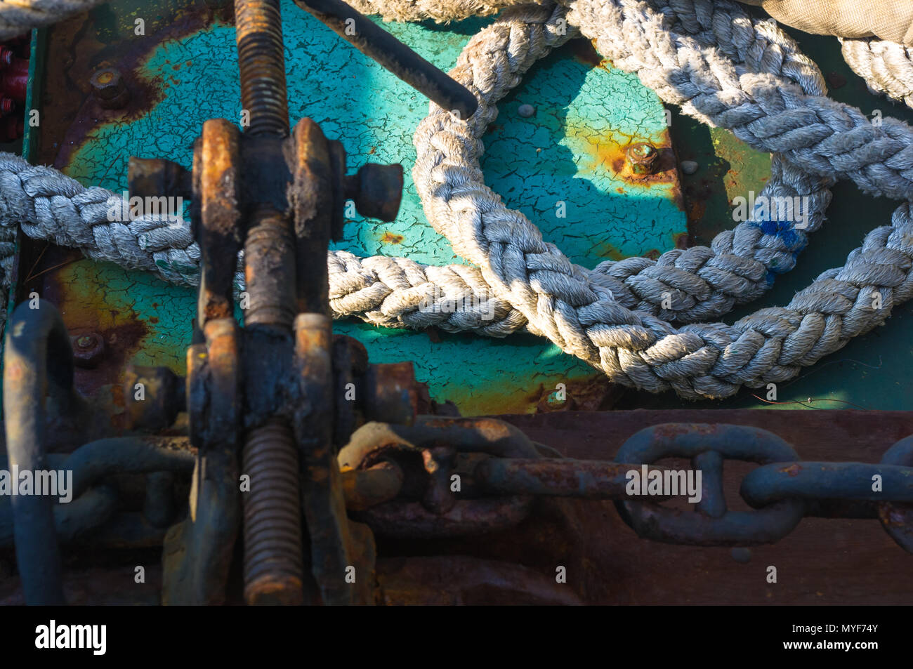 Old braided rope on the wooden deck of a sea boat, cleats, anchor ...
