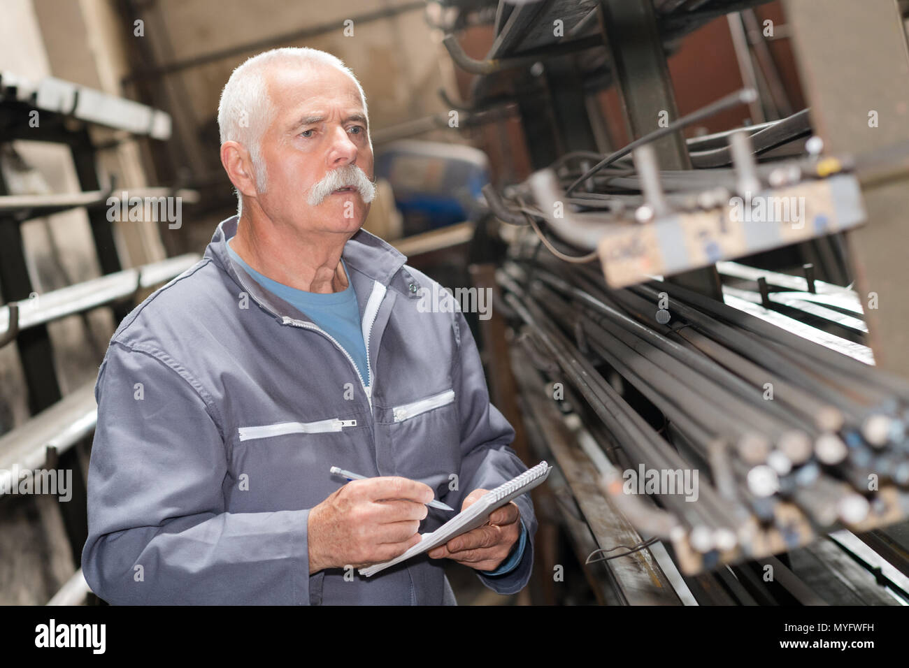 senior worker counting metal bars in warehouse Stock Photo - Alamy