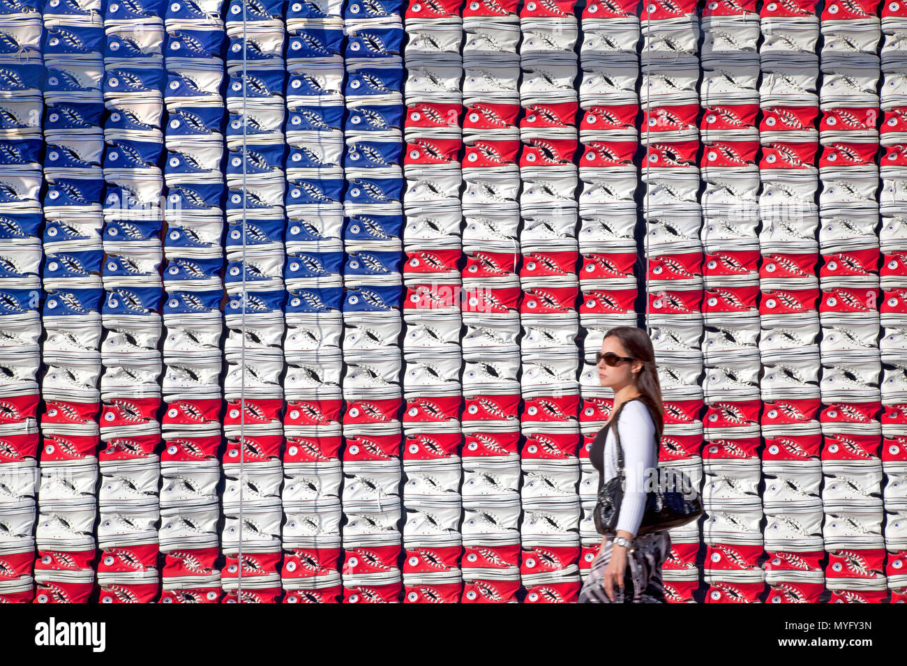 Woman walking past shoe store with American flag display, Los Angeles ...