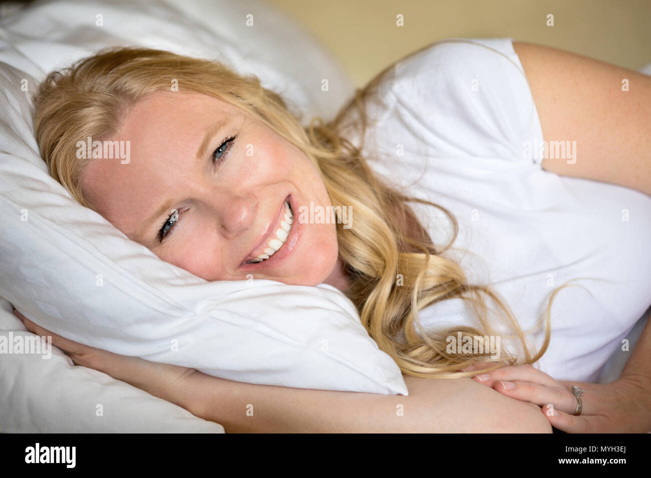 Beautiful blonde woman smiling getting ready for bed Stock Photo - Alamy