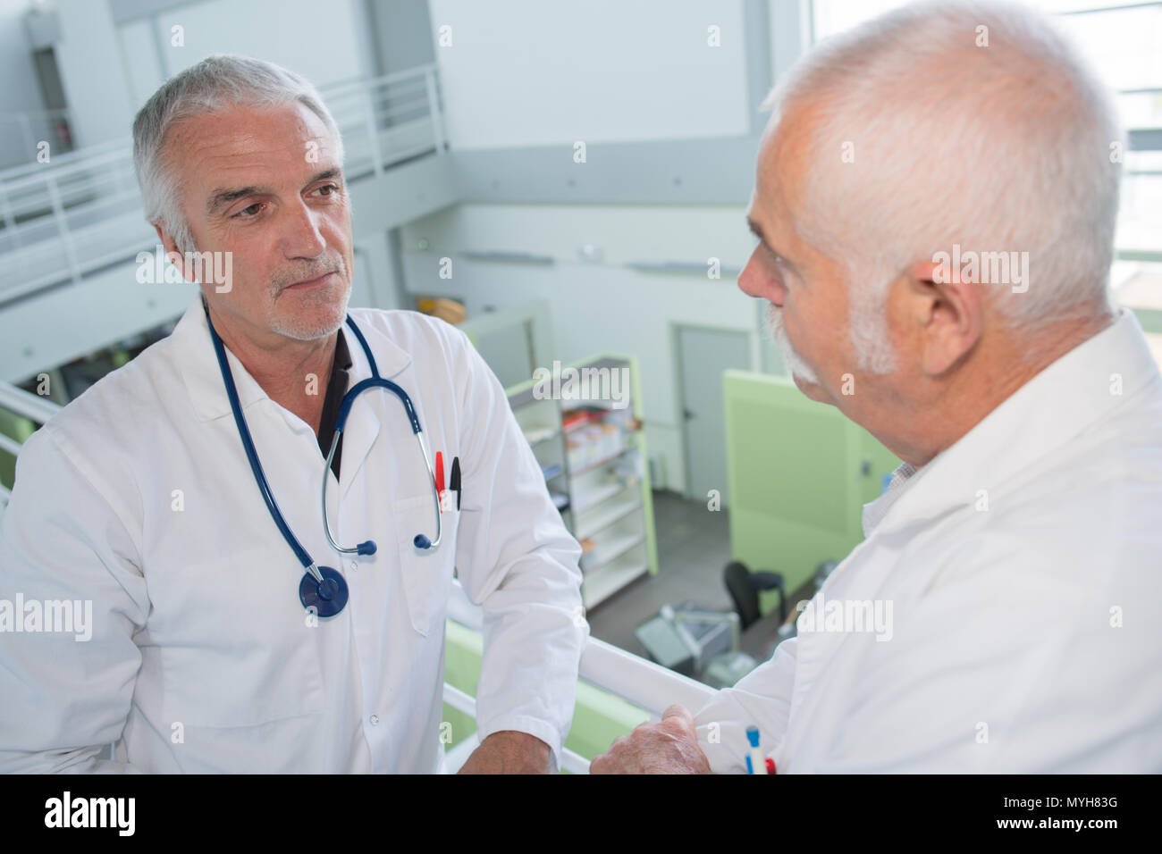 two doctors talking as they walk through modern hospital Stock Photo ...