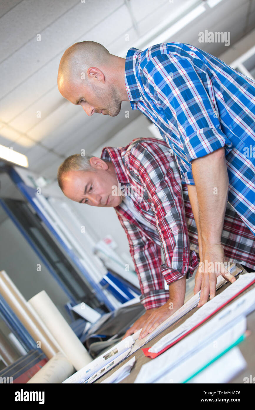 two men designers looking at plans Stock Photo - Alamy