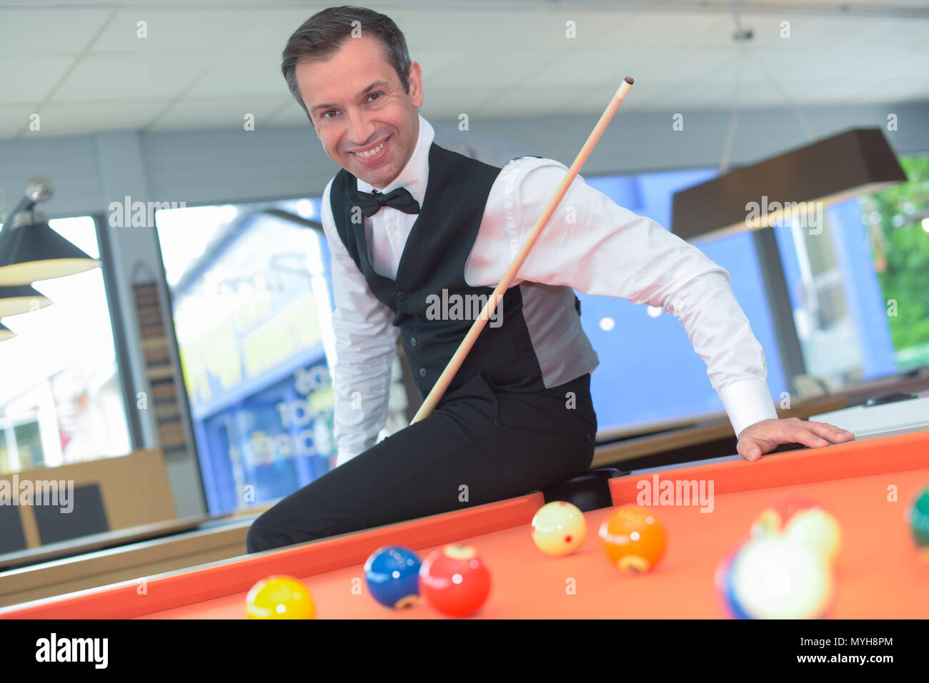 male adult standing with cue playing billiard Stock Photo - Alamy
