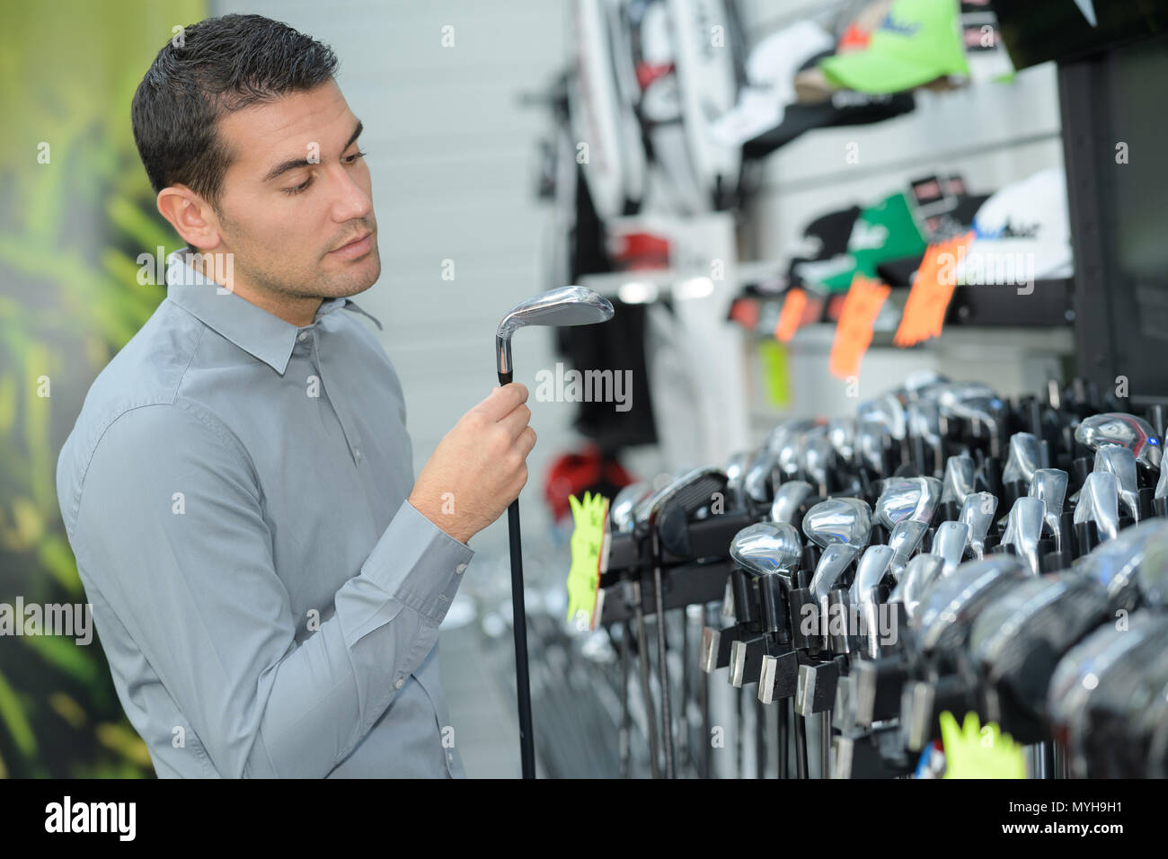 man inspecting the golf clubs Stock Photo - Alamy