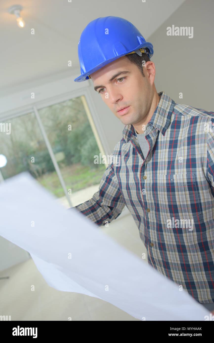 engineer with blueprint in building construction site Stock Photo - Alamy