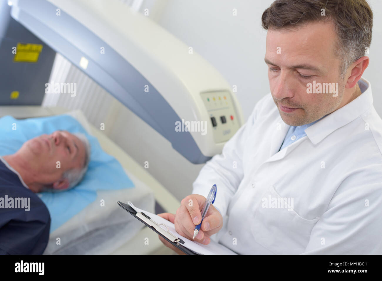 doctor reviewing chart of patient about to have mri scan Stock Photo ...