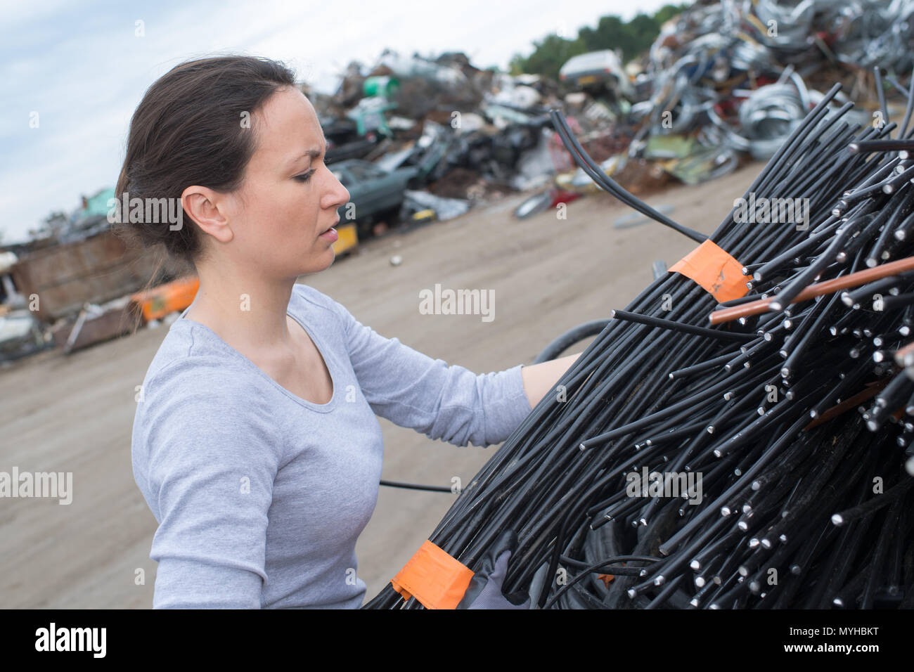 Woman lifting bundle of cables Stock Photo - Alamy