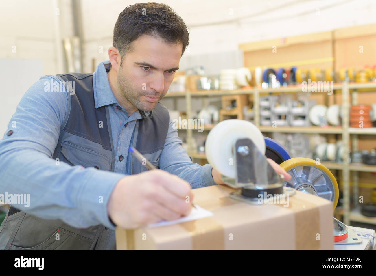 man writing label for cardboard box Stock Photo - Alamy