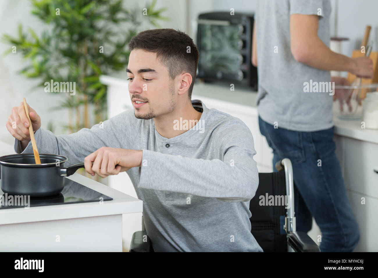 disabled young man in wheelchair cooking in the kitchen Stock Photo - Alamy