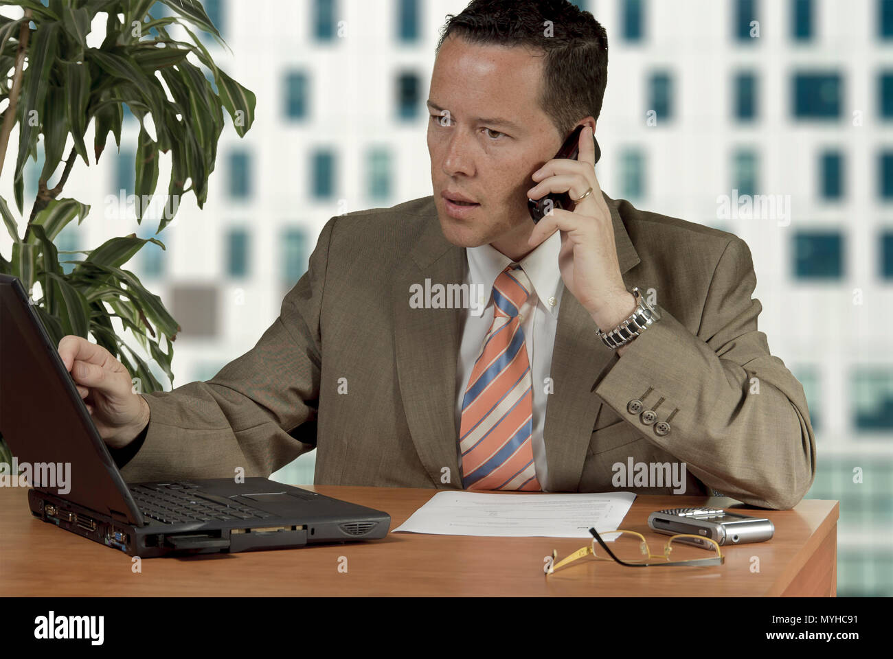 Office worker on phone at office Stock Photo - Alamy