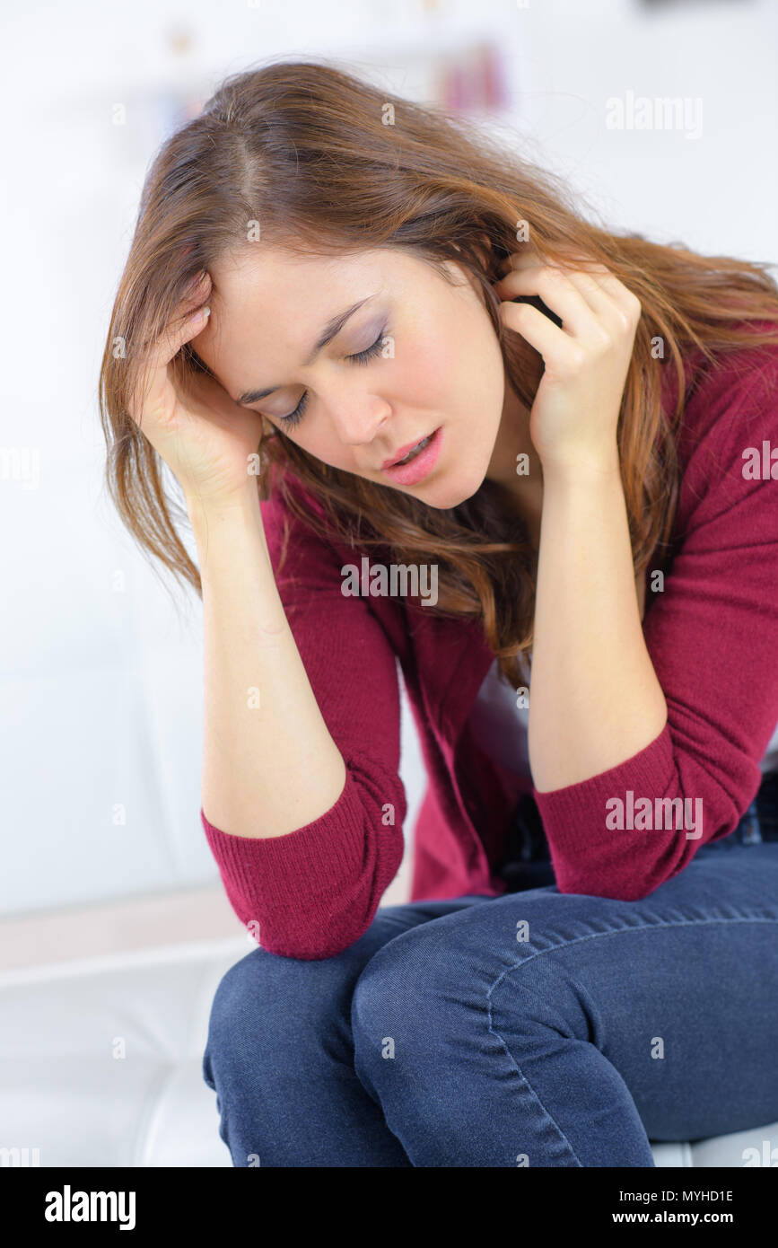 Distressed lady with head in her hands Stock Photo - Alamy