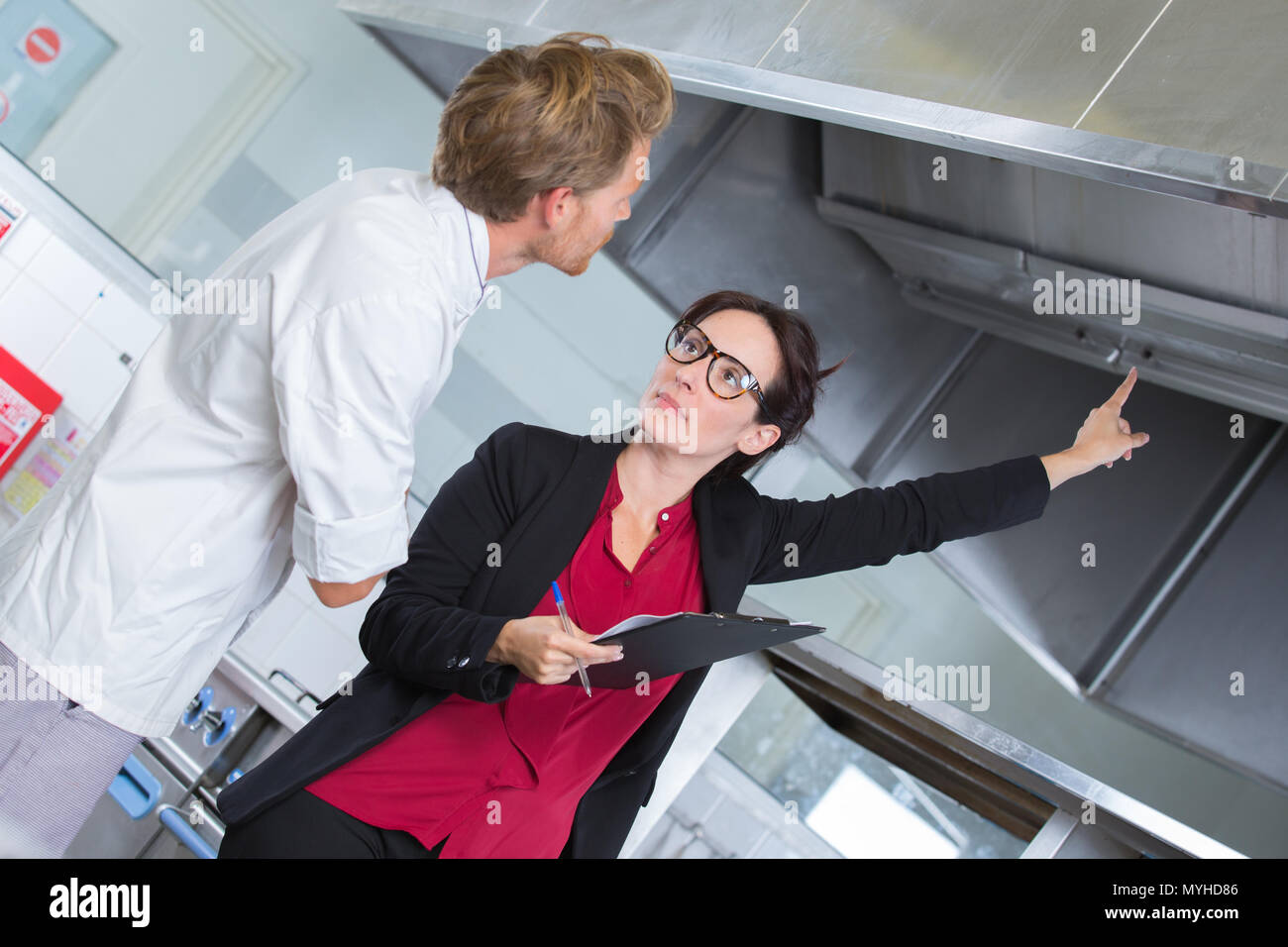 kitchen inspector pointing to extractors Stock Photo - Alamy