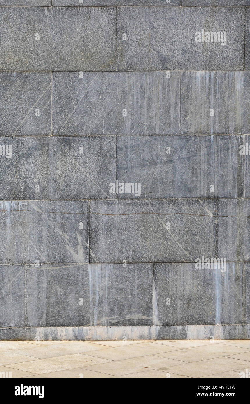 The texture of a wall of large granite tiles that are covered with ...