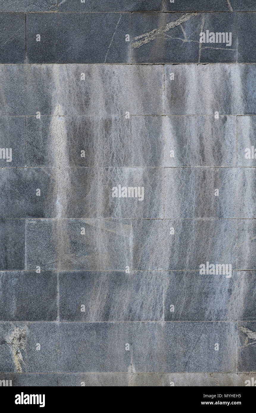The texture of a wall of large granite tiles that are covered with ...