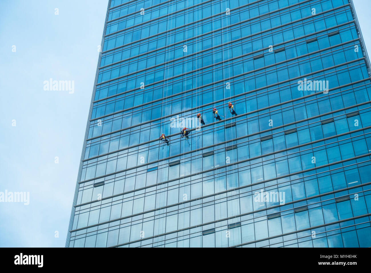 Window cleaners on face of glass office building in Shenzhen China ...