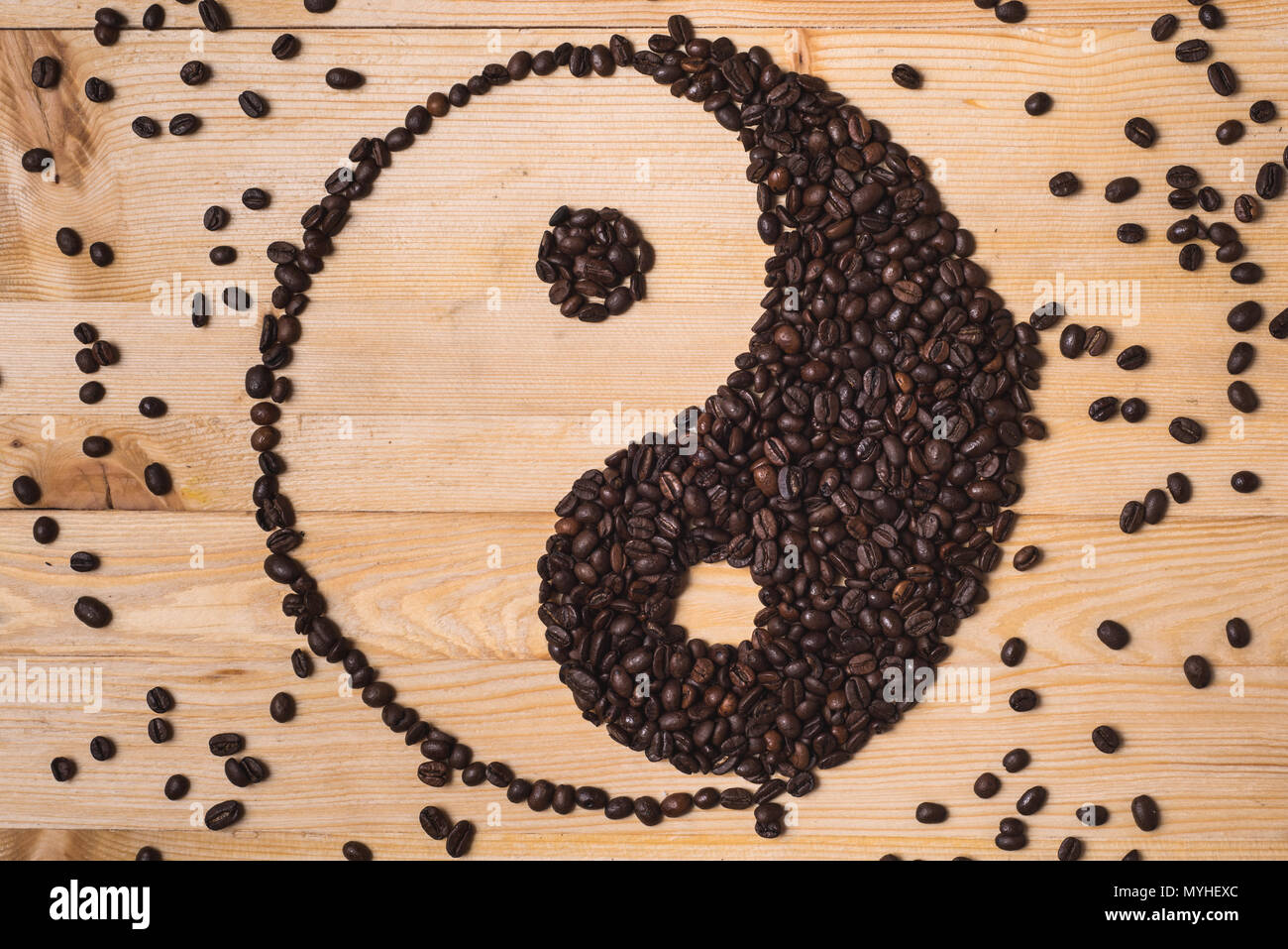 ying yang coffee composition with toasted coffee beans spreaded on wood ...