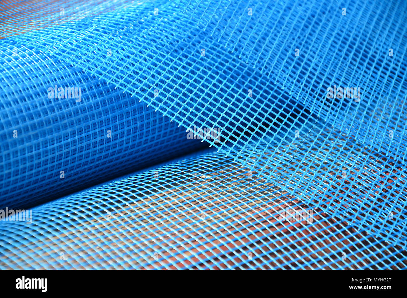 Close-up texture of a blue reinforcing mesh rolled up in a roll ...