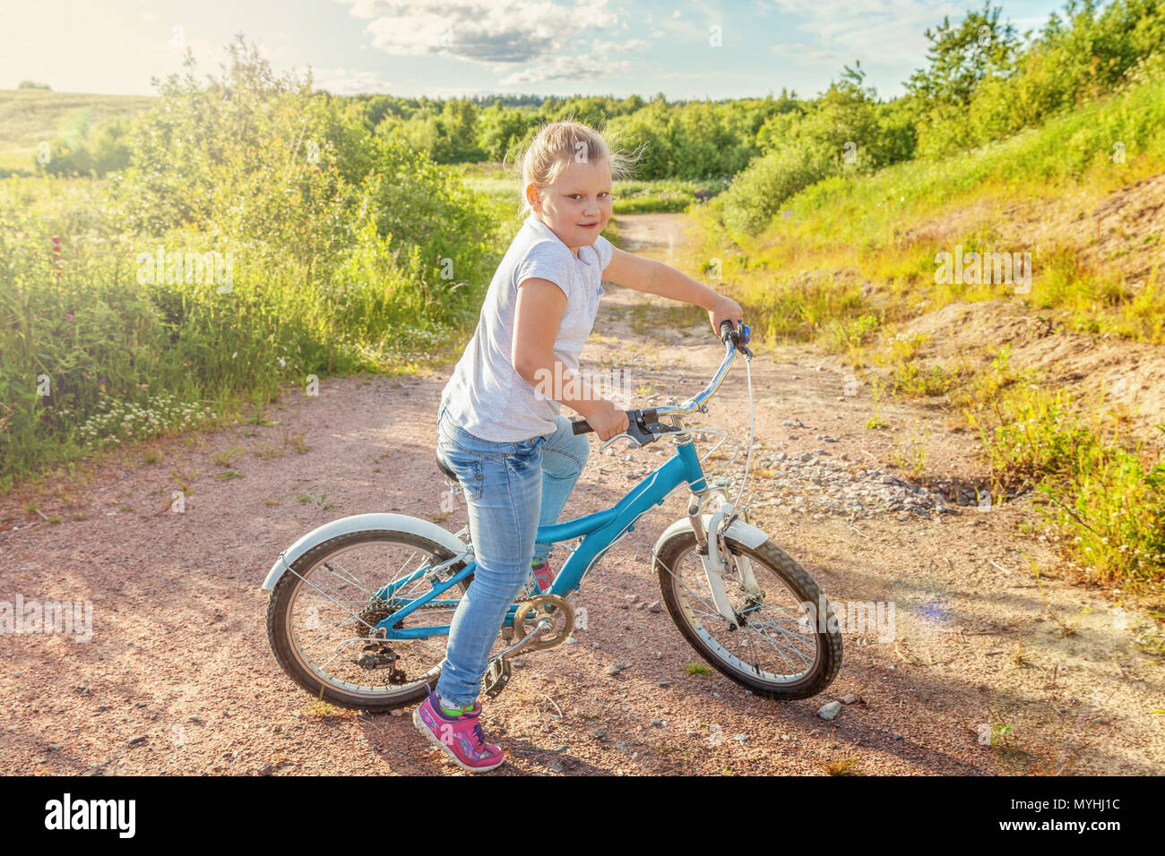 Happy child riding bike. Young girl on bicycle in sunny summer park ...