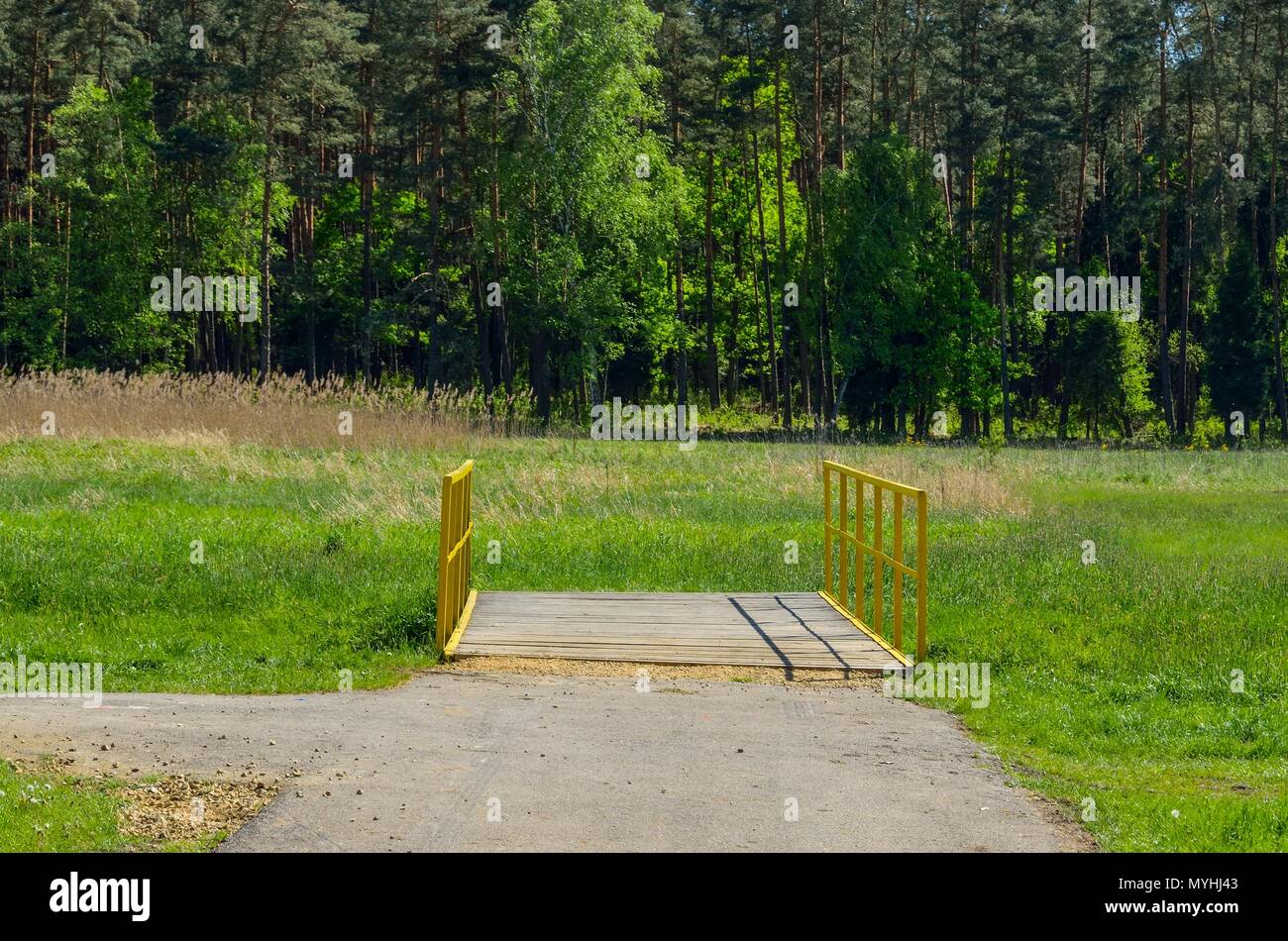 Rural spring landscape. Bridge over a small river in a clearing Stock ...