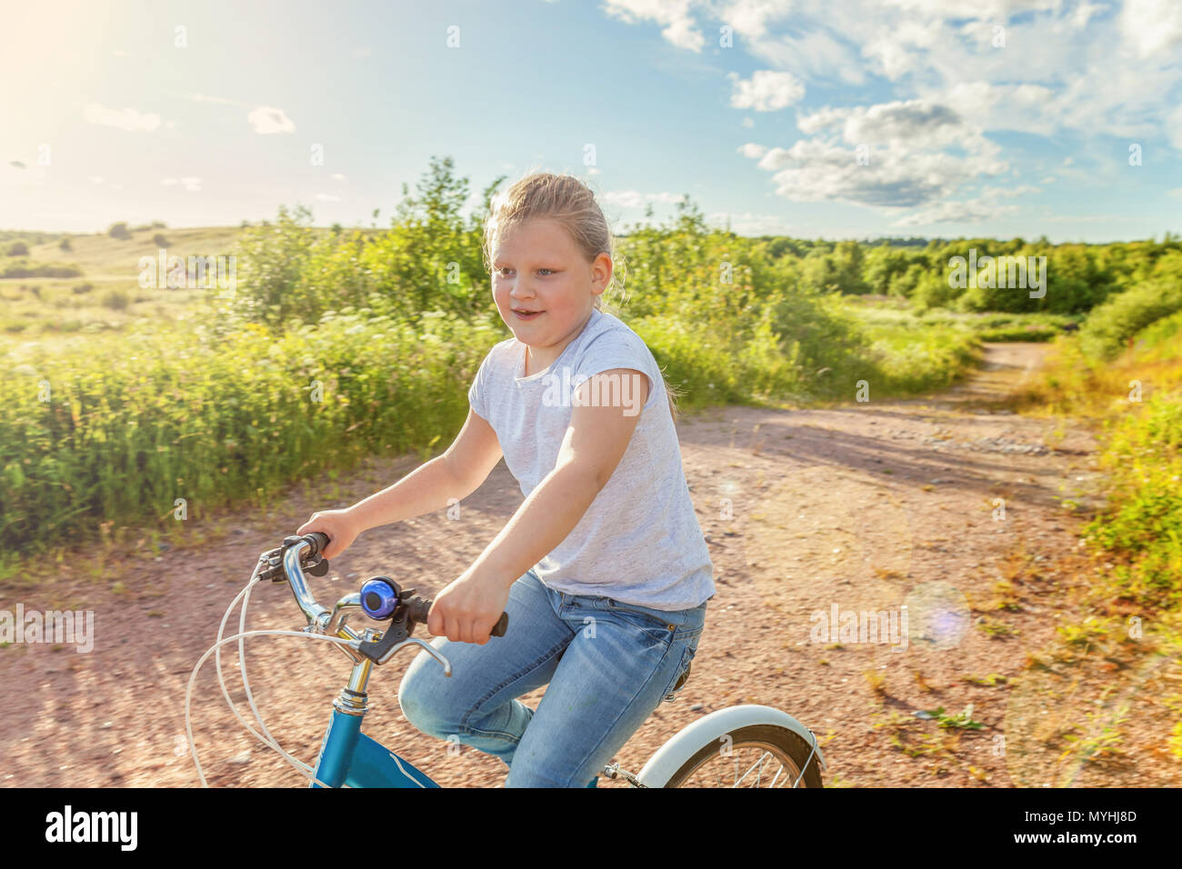 Happy child riding bike. Young girl on bicycle in sunny summer park ...