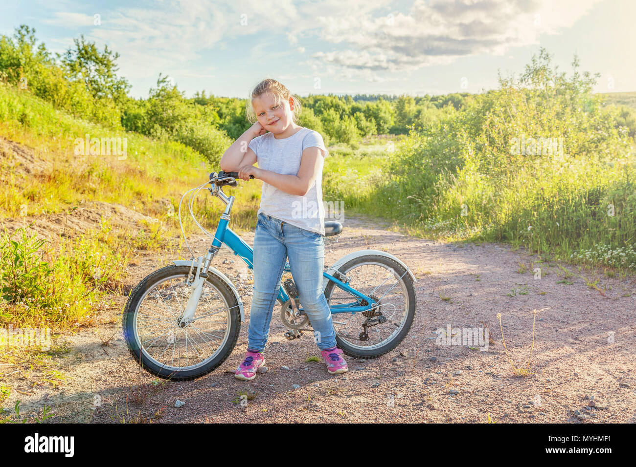 Happy child riding bike. Young girl on bicycle in sunny summer park ...