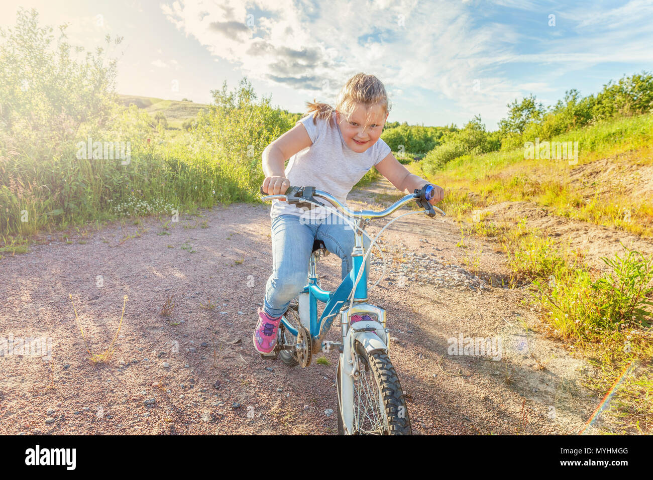 Happy child riding bike. Young girl on bicycle in sunny summer park ...