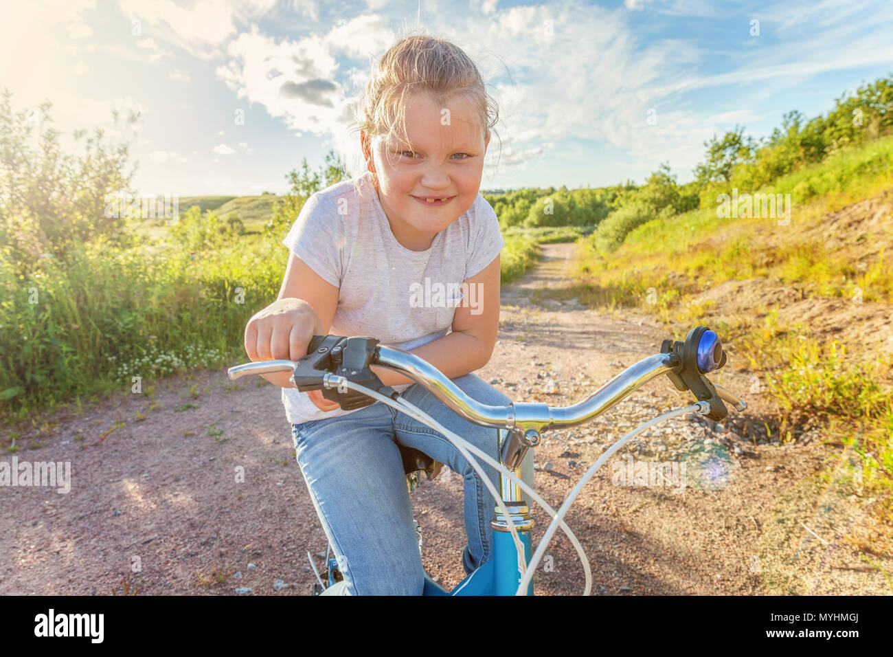 Happy child riding bike. Young girl on bicycle in sunny summer park ...
