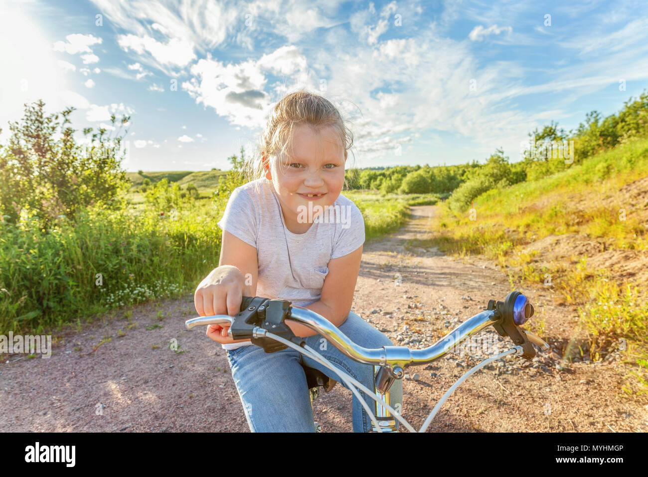 Happy child riding bike. Young girl on bicycle in sunny summer park ...