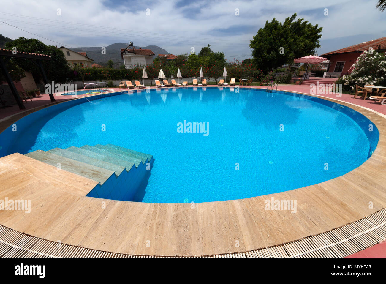 Round swimming pool on open air with beautiful clear water, sun ...