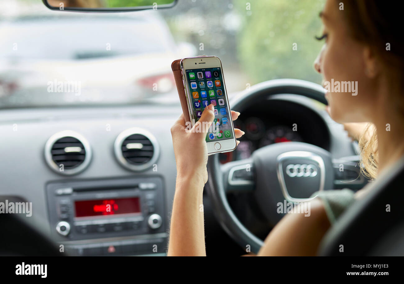 Woman driving whilst using mobile phone Stock Photo - Alamy