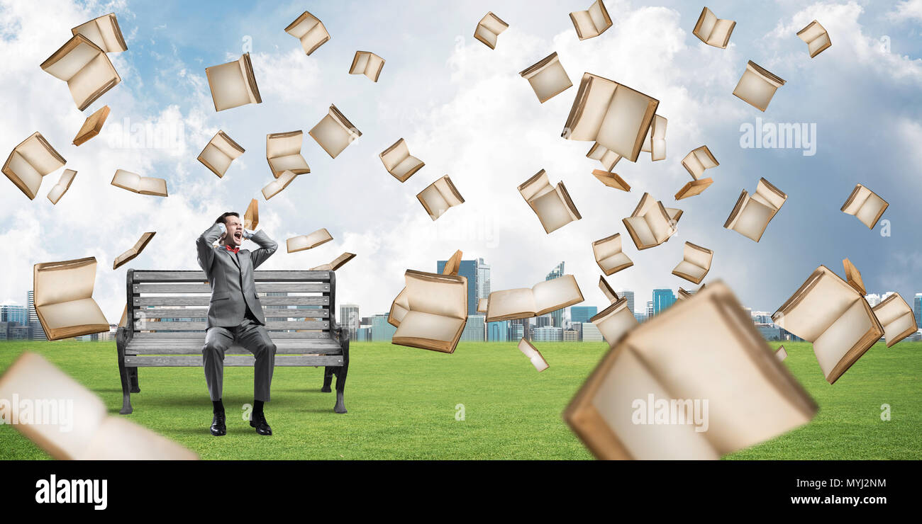 Many old books falling from above and student guy sitting on bench ...