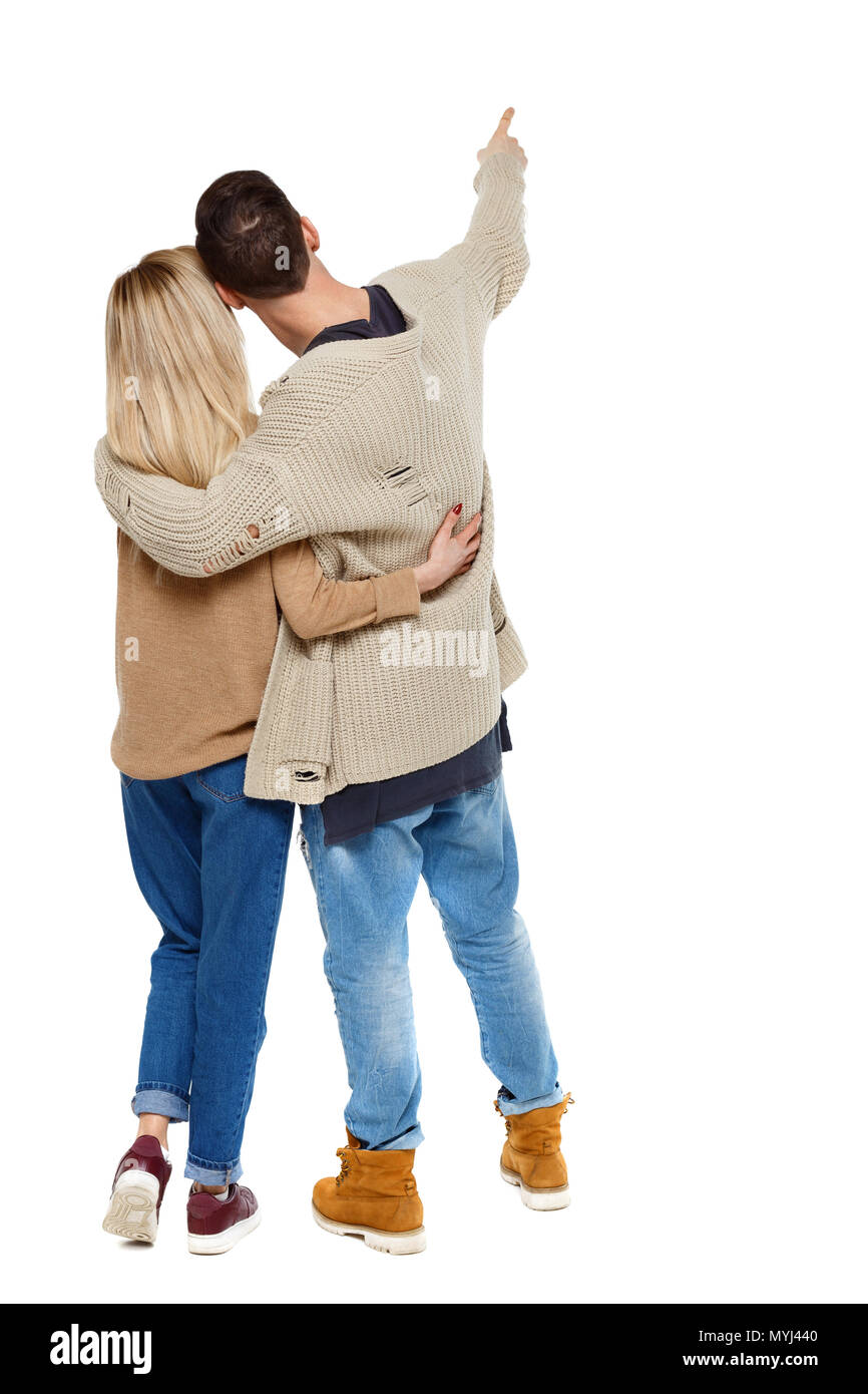 Back view of a heterosexual couple who hugs and points out. Rear view ...