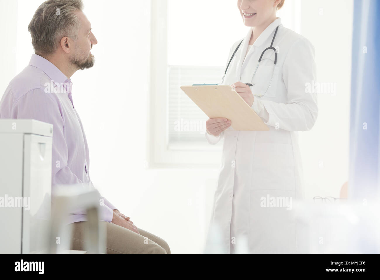 Professional doctor writing a prescription for a sick man in the ...