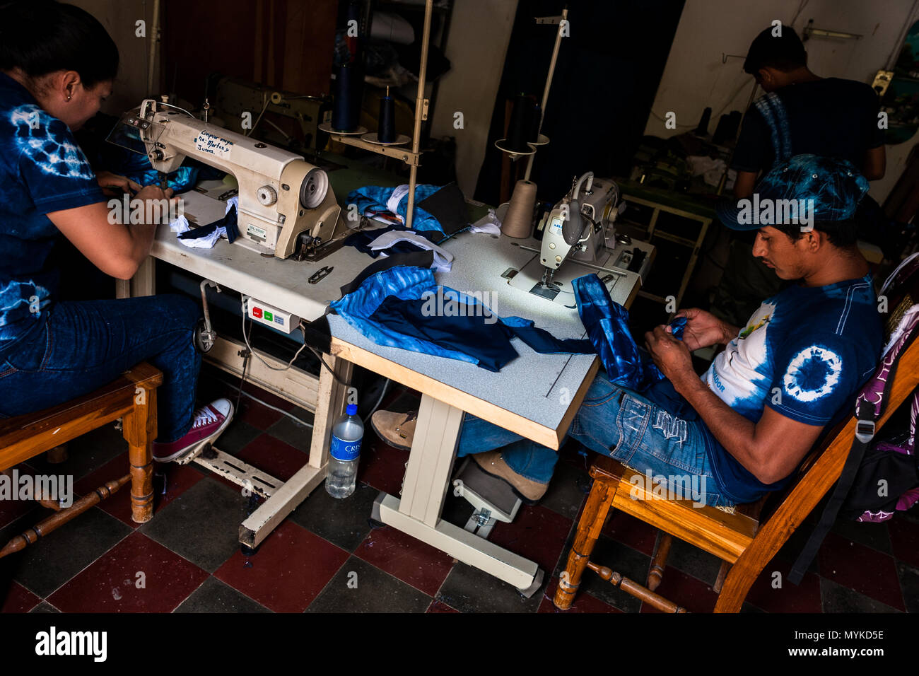 A Salvadoran seamster sews an indigo-dyed tote bag on the sewing ...