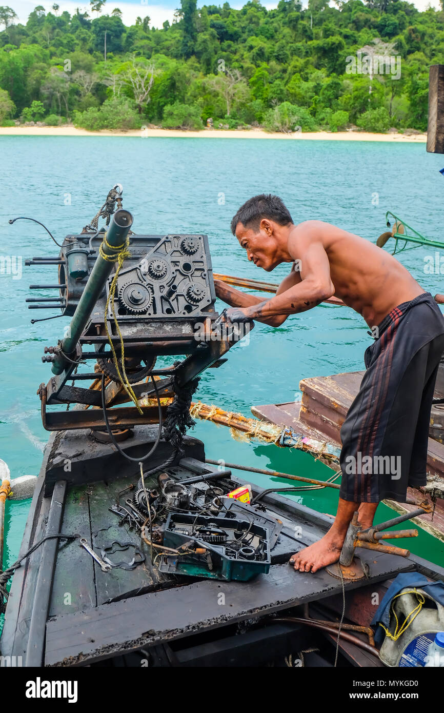 May 3 2018 - Myeik ARchipelago, Myanmar. Fisherman fixing a boat engine ...