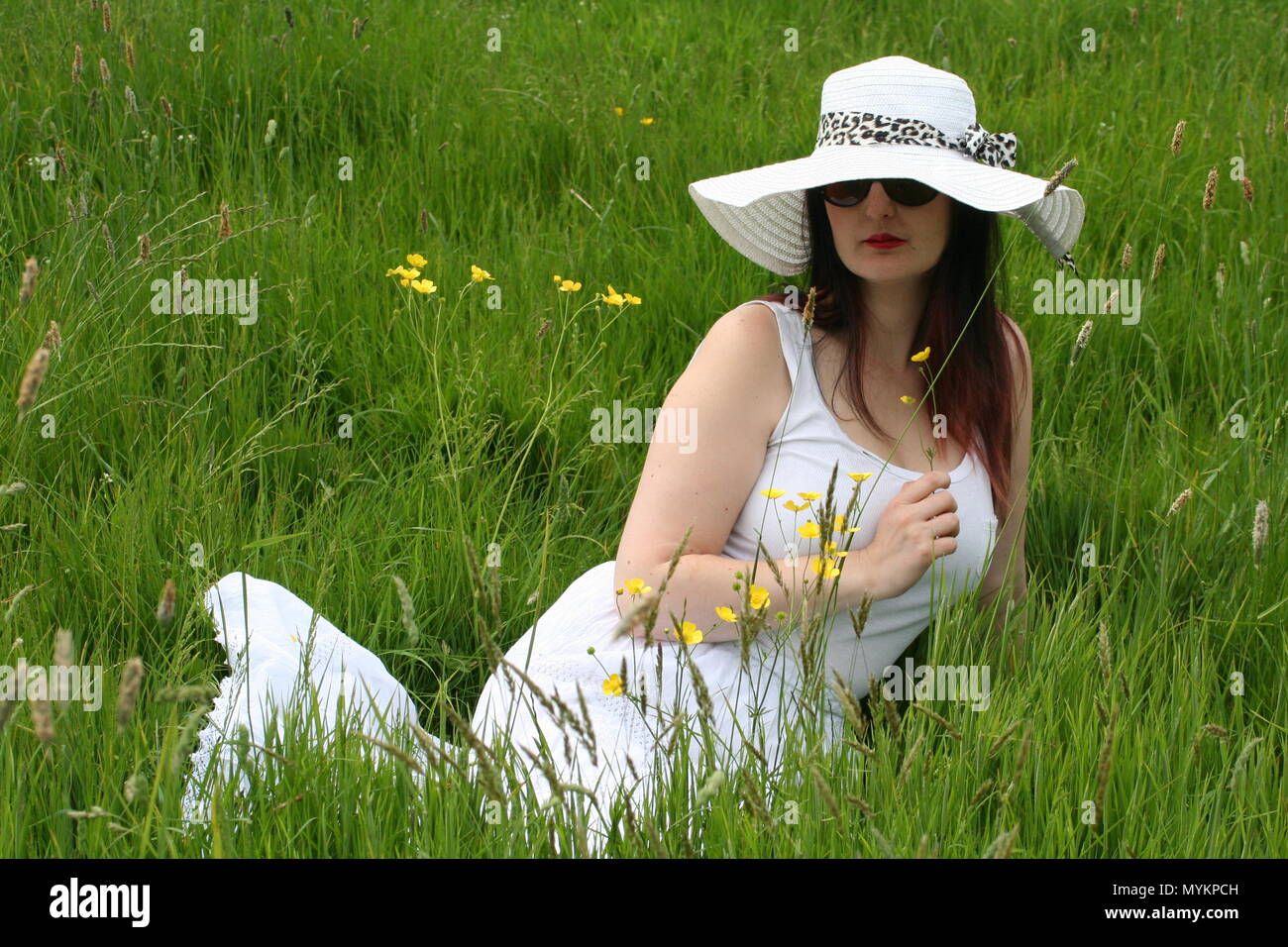 beautiful young lady sat in countryside, meadow Stock Photo - Alamy