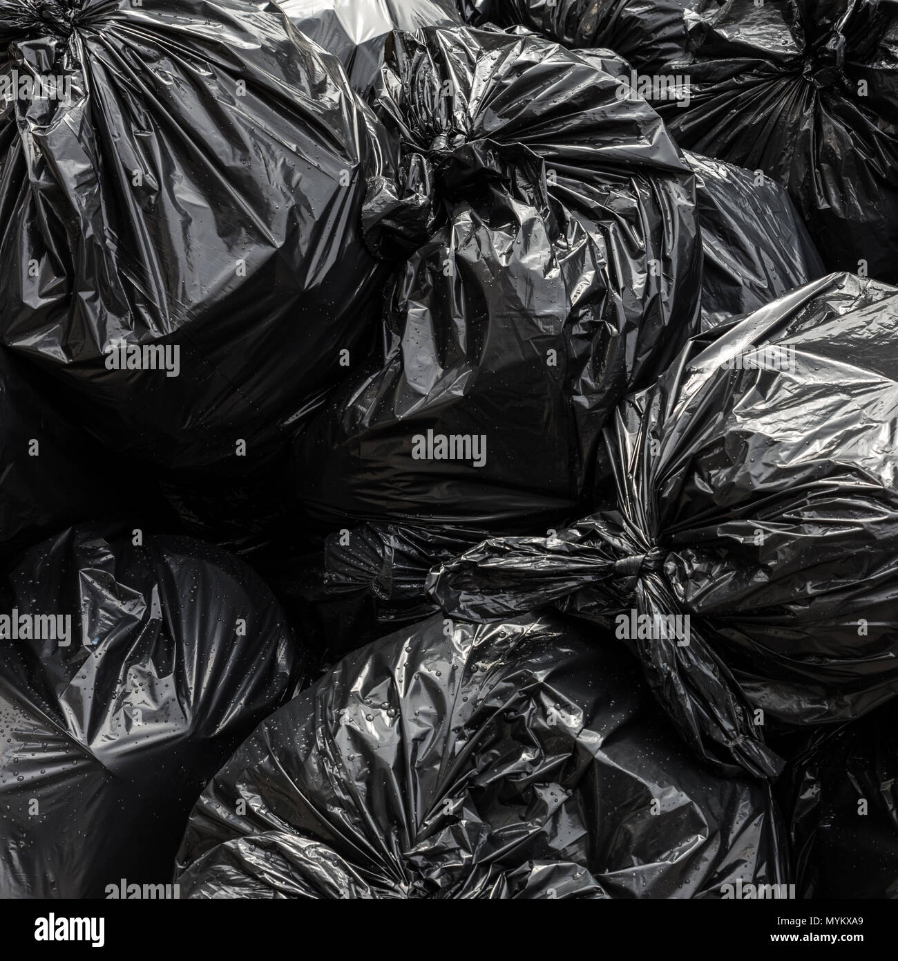 Pile of black waste plastic bin bag background Stock Photo - Alamy