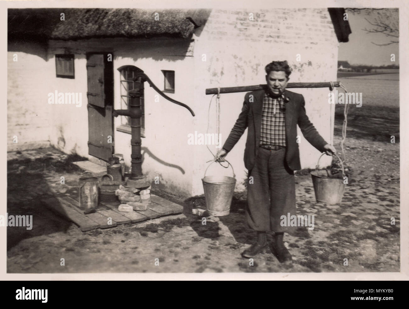 A Danish peasant farmer, circa 1925, outside his thatched cottage. He ...