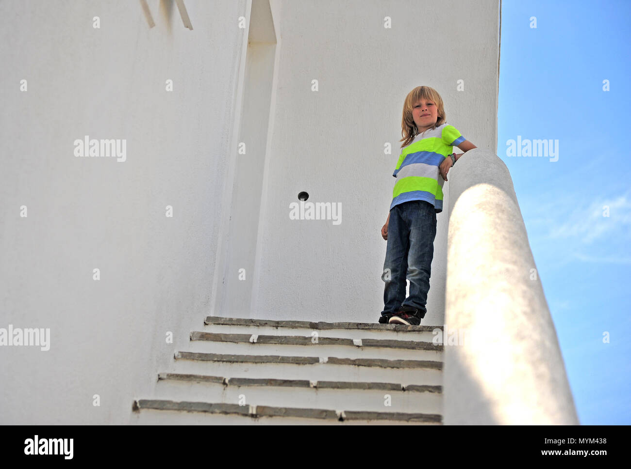 Little blond boy standing outside the house Stock Photo - Alamy