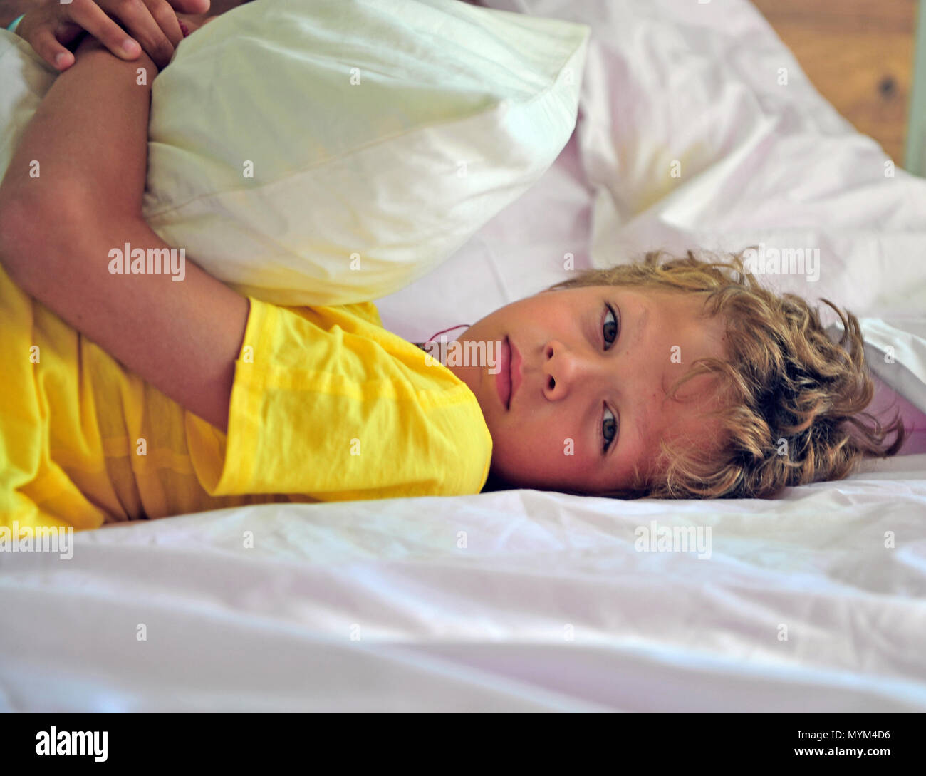 Awaked boy lying in the bed on morning Stock Photo - Alamy
